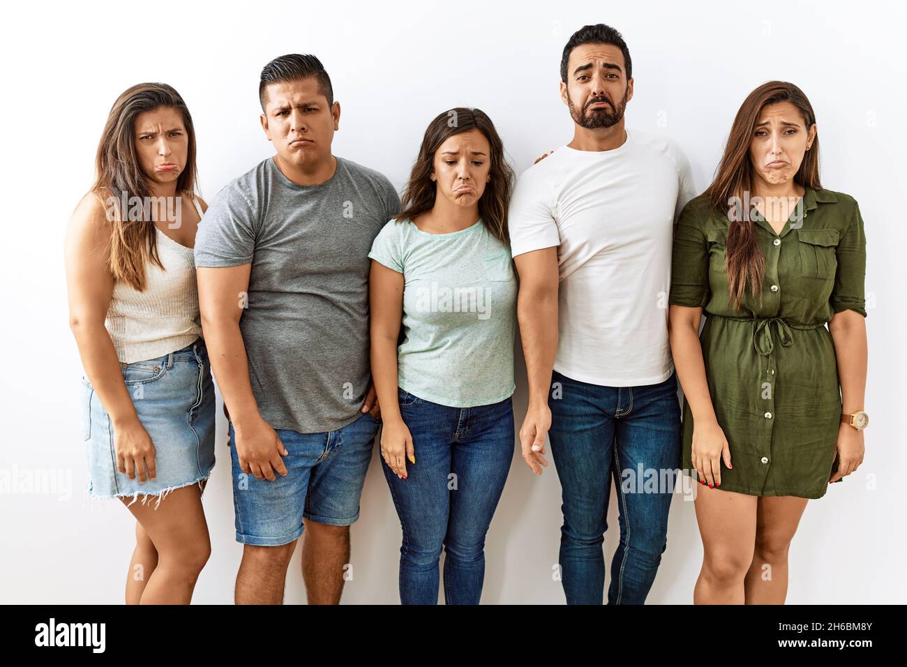 Group of young hispanic friends standing together over isolated ...