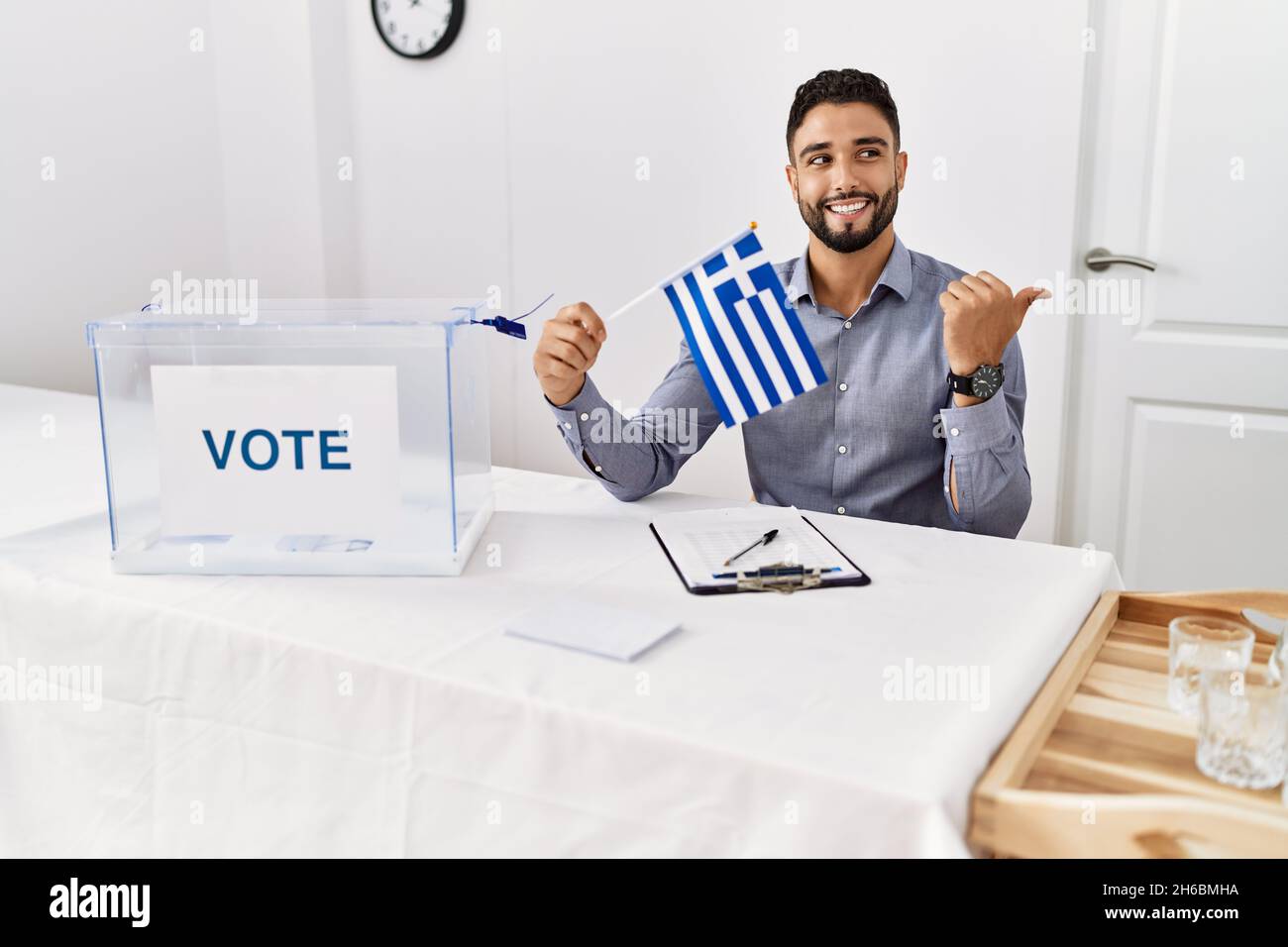 Young handsome man with beard at political campaign election holding ...