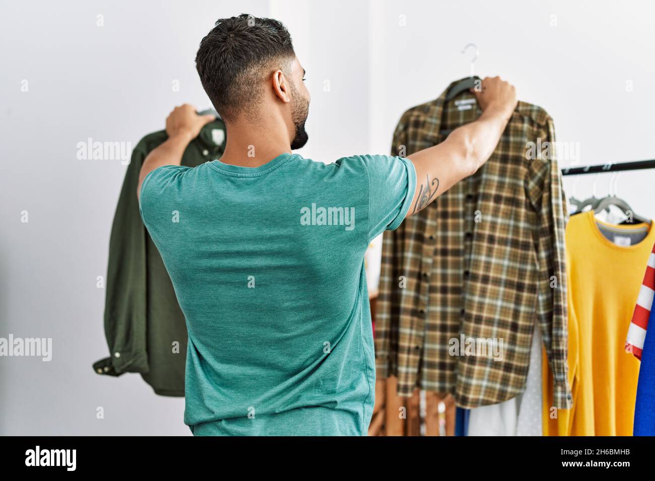 Young arab man customer on back view shopping at clothing store Stock ...