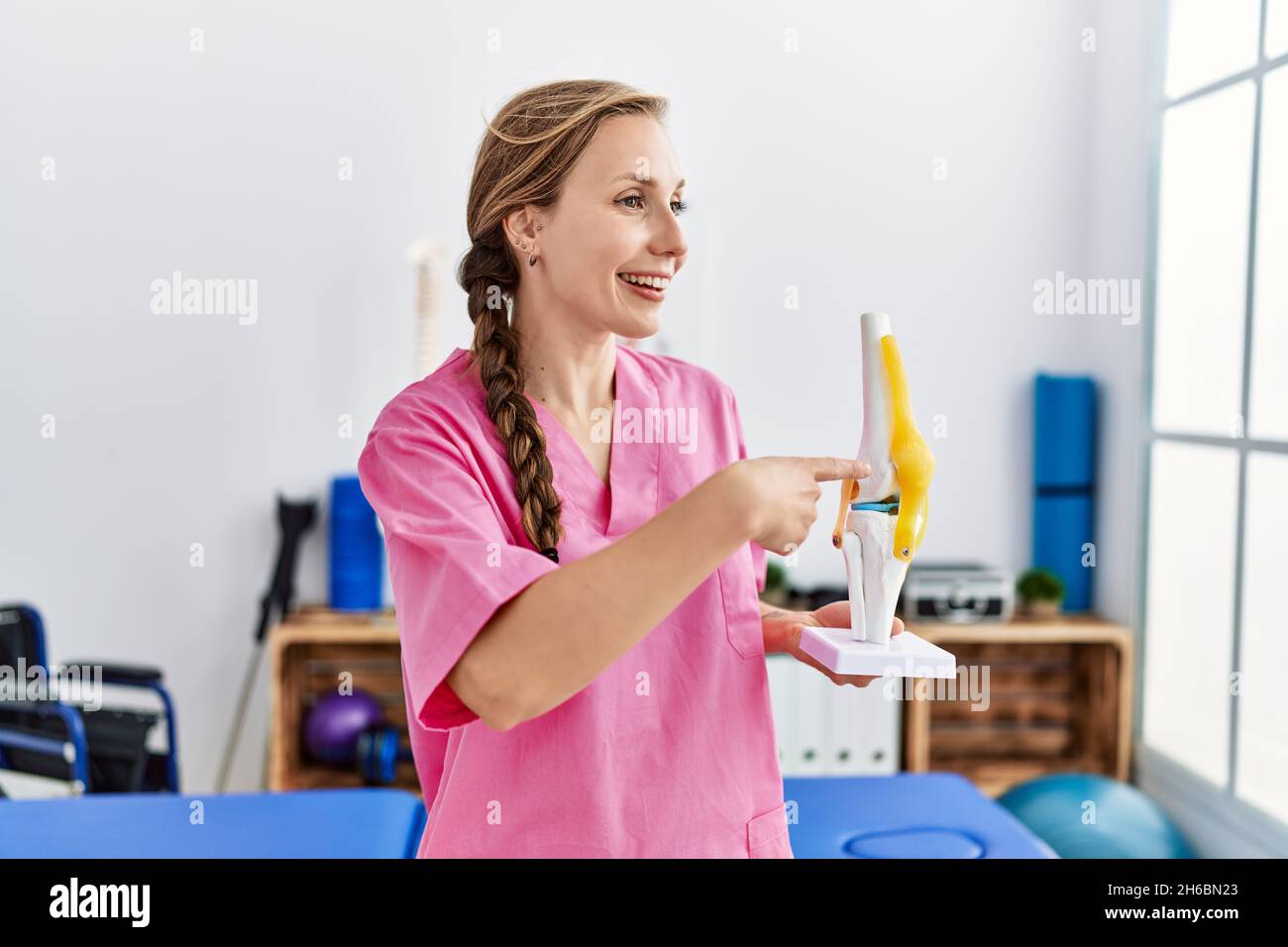 Young caucasian woman wearing physiotherapist uniform holding ...