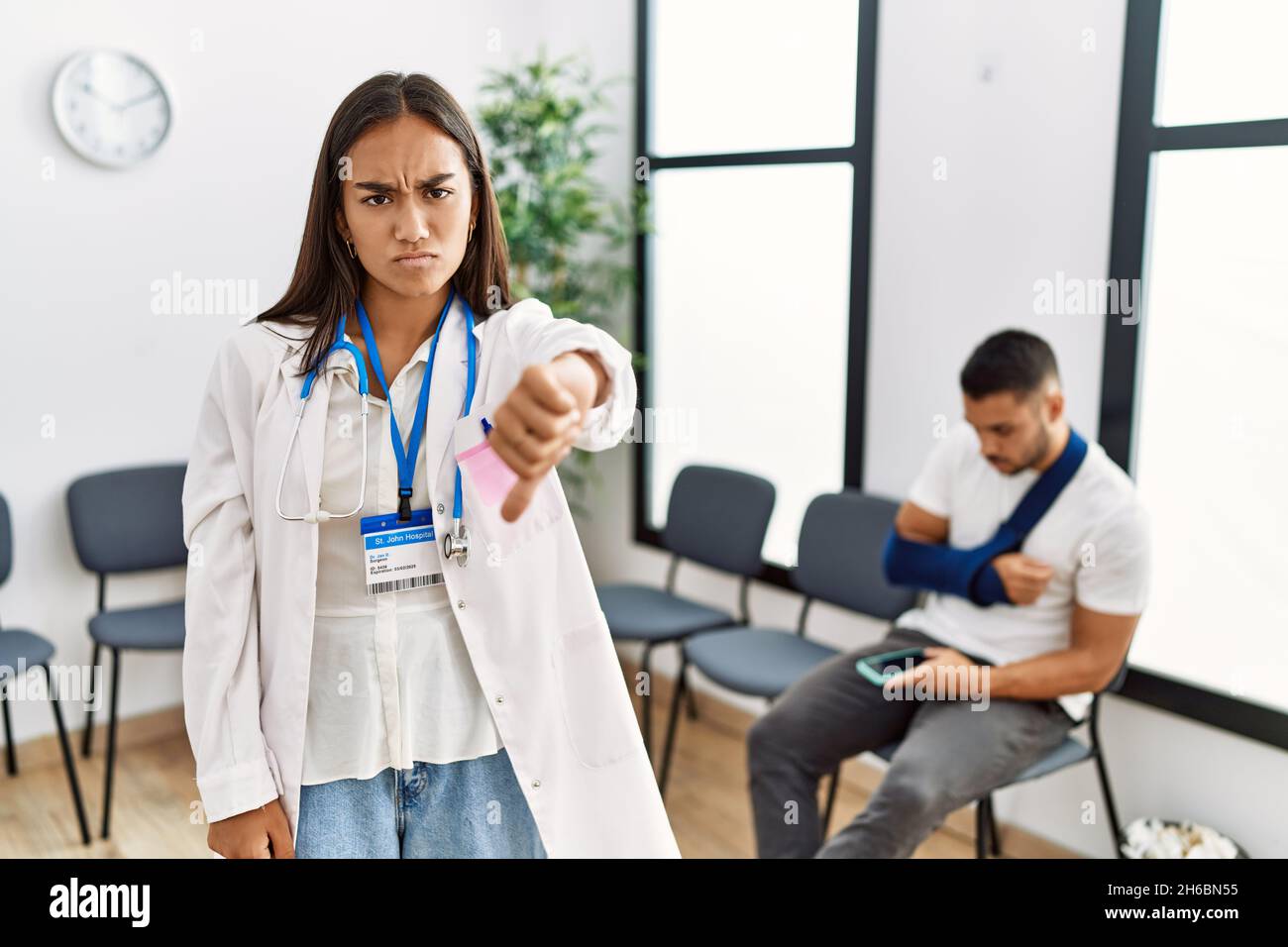 Young asian doctor woman at waiting room with a man with a broken arm ...