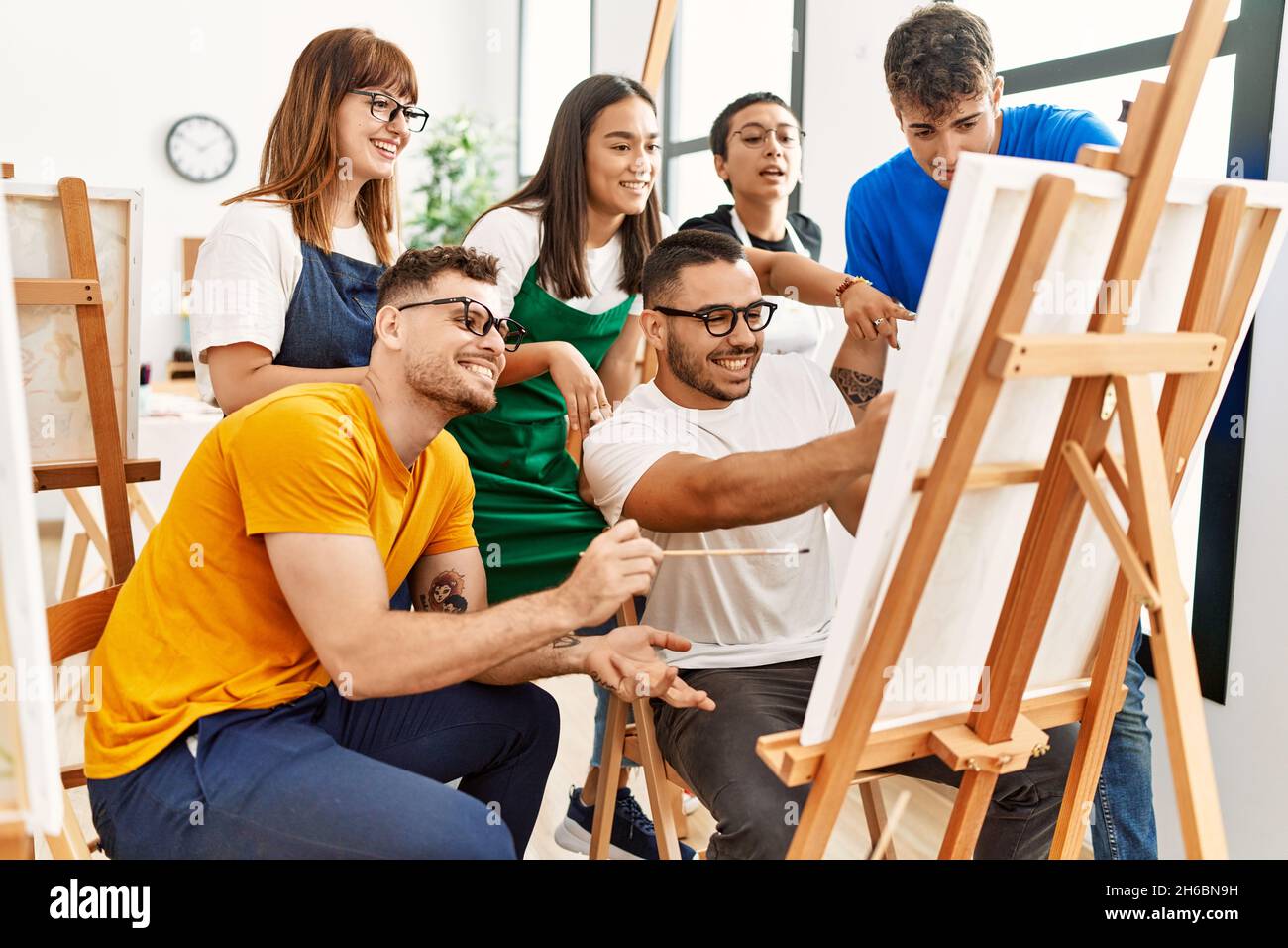 Group of people smiling happy and looking draw of partner at art studio ...