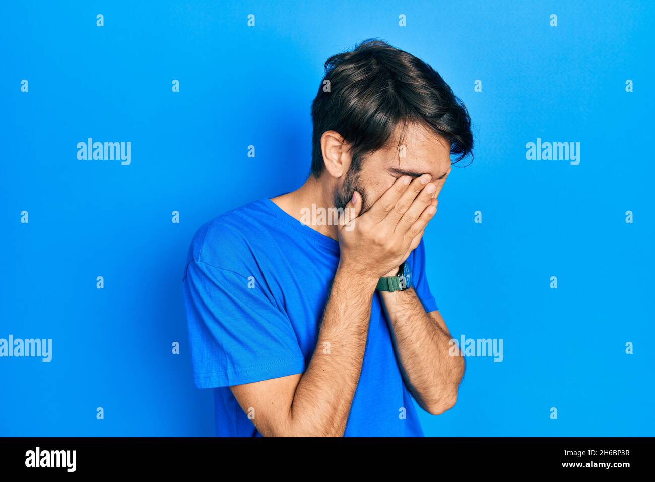 Young hispanic man wearing casual clothes with sad expression covering ...