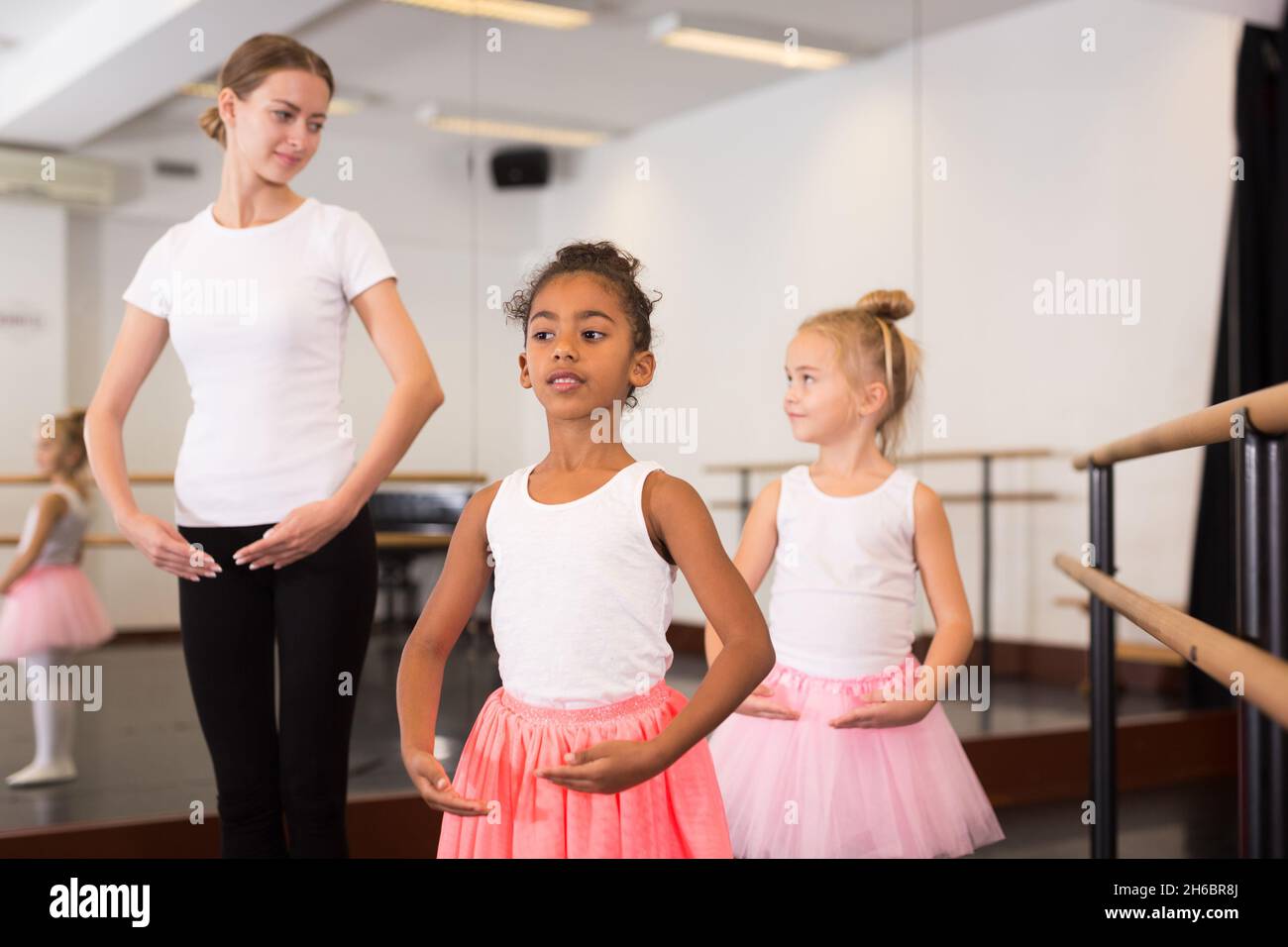 Dance teacher helping her little girls students Stock Photo - Alamy