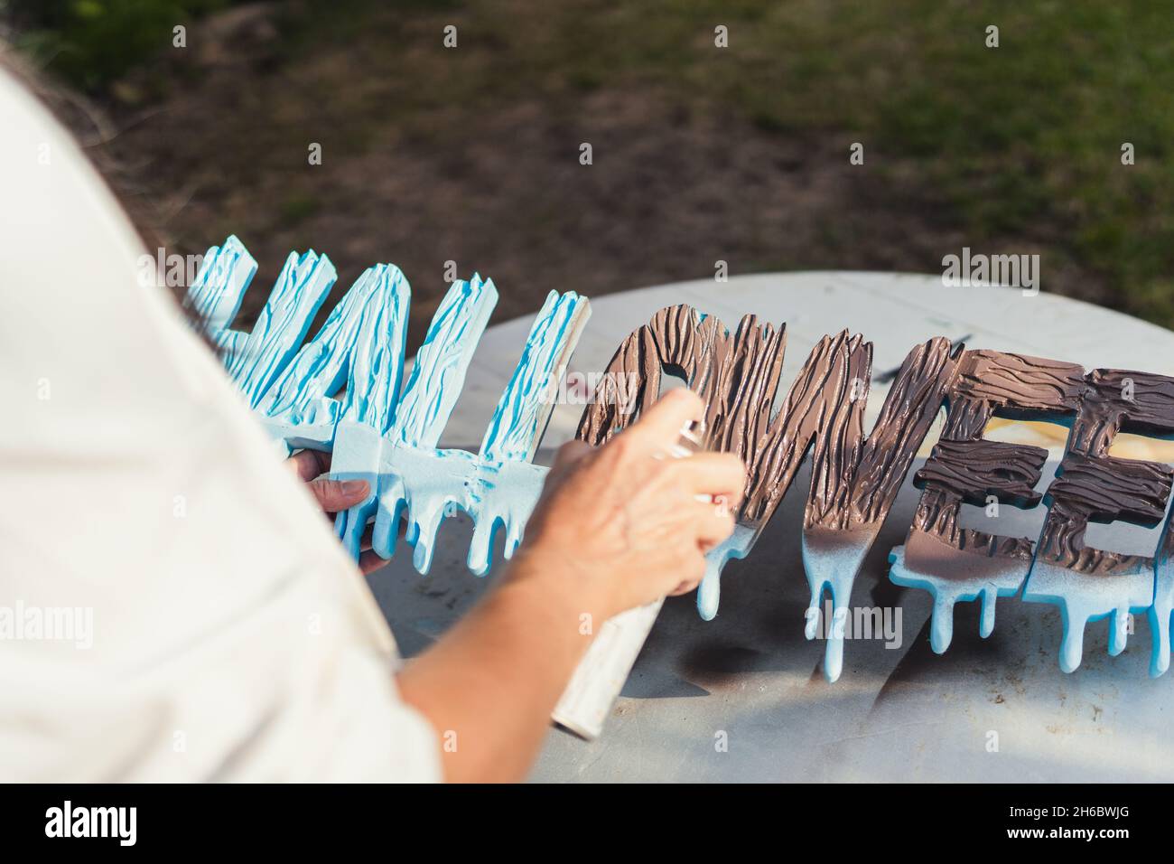 Person painting polystyrene letters with brown paint in spray Stock ...