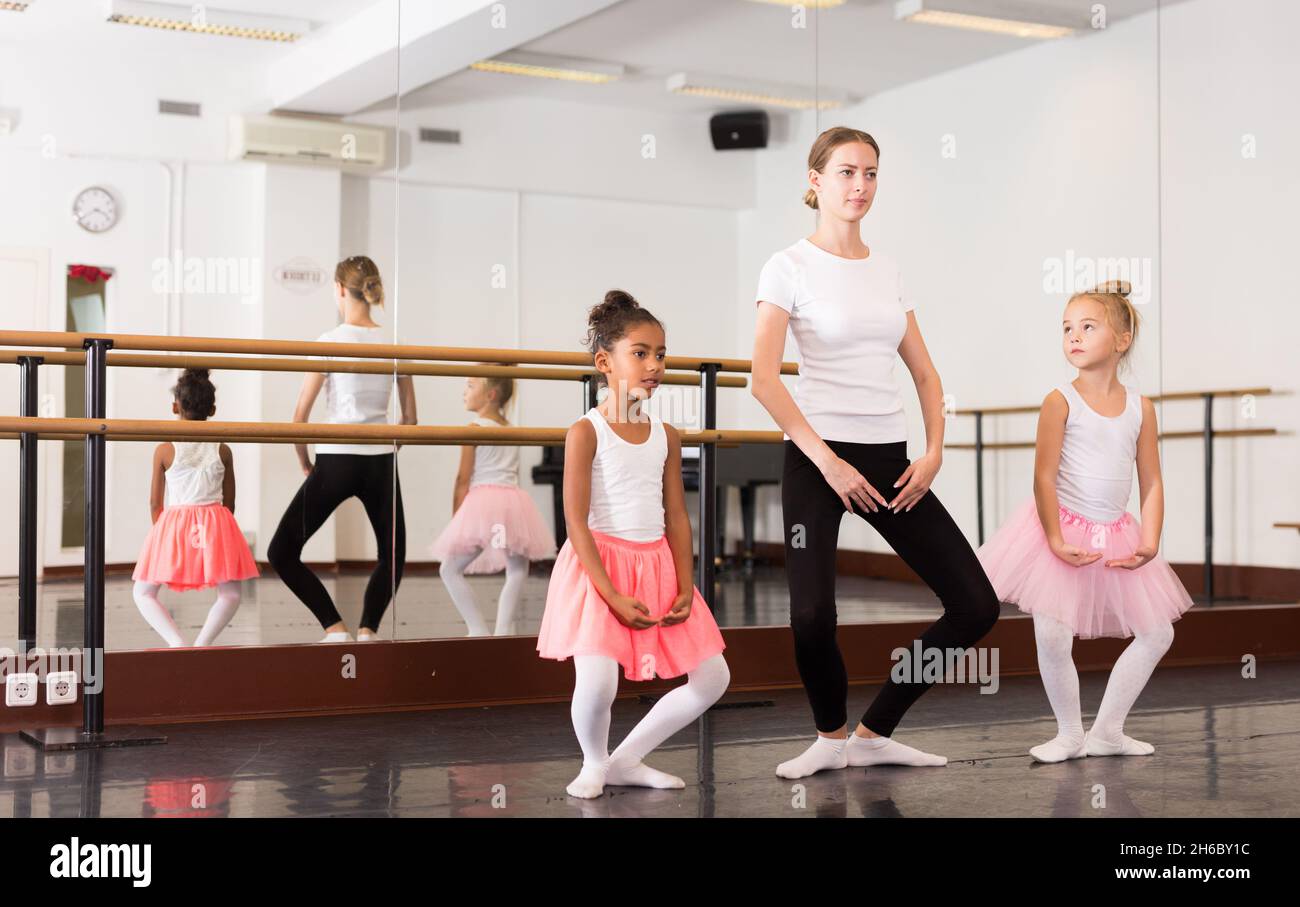 Dance teacher helping her little girls students Stock Photo - Alamy