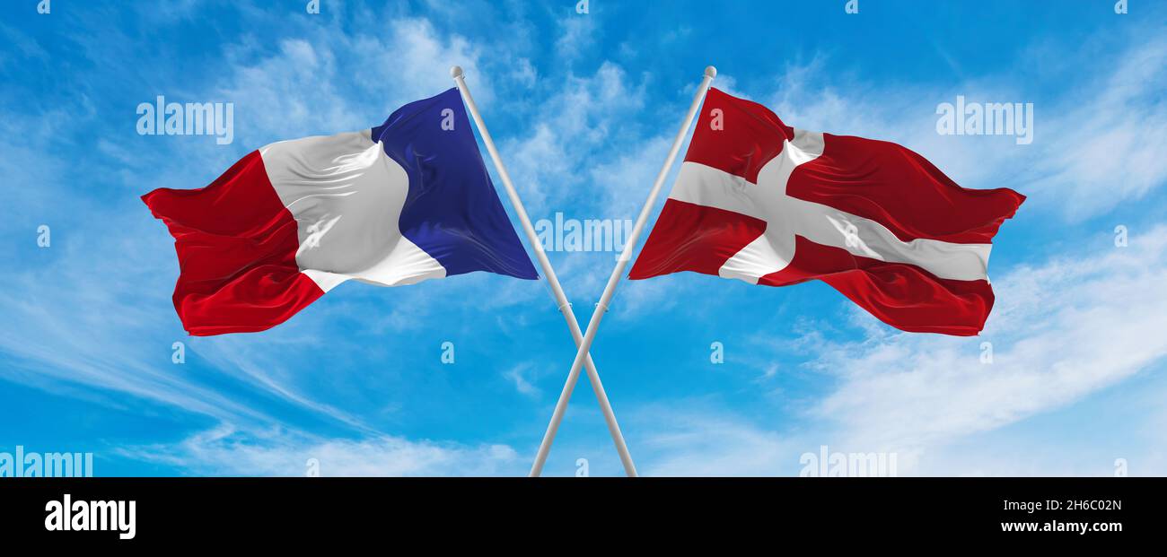 crossed national flags of France and denmark flag waving in the wind at ...