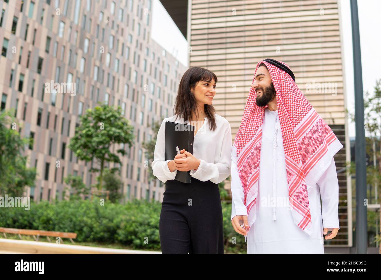 Low angle of happy Arab male smiling and talking with female manager ...