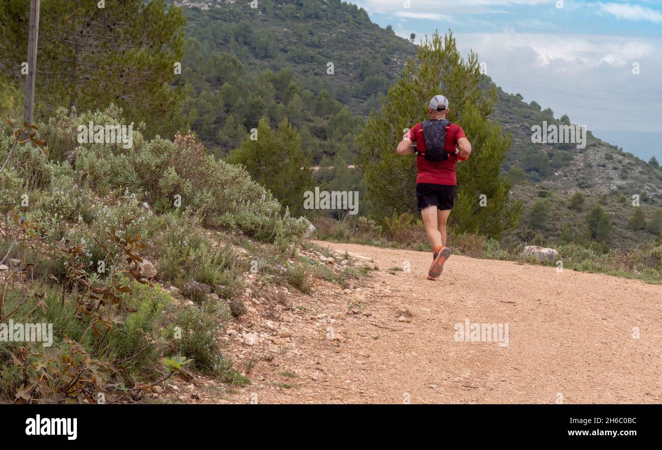 A hiker running on a way in a mountain Stock Photo - Alamy
