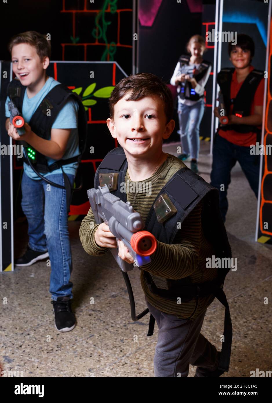 boy aiming laser gun at other players during lasertag game Stock Photo ...