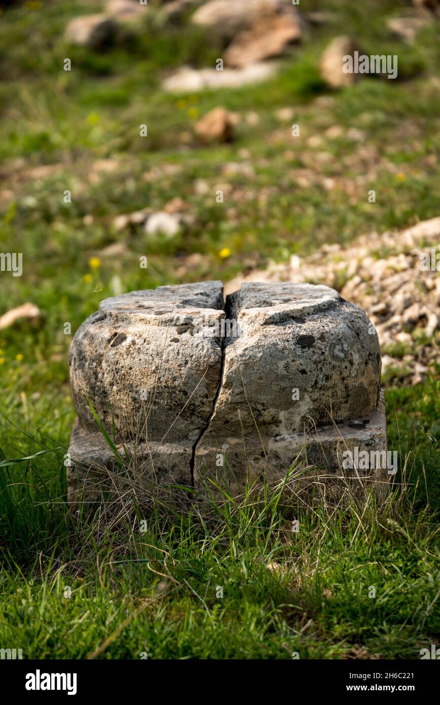 base of a very old stone column in a Greek ruins surrounded by ...