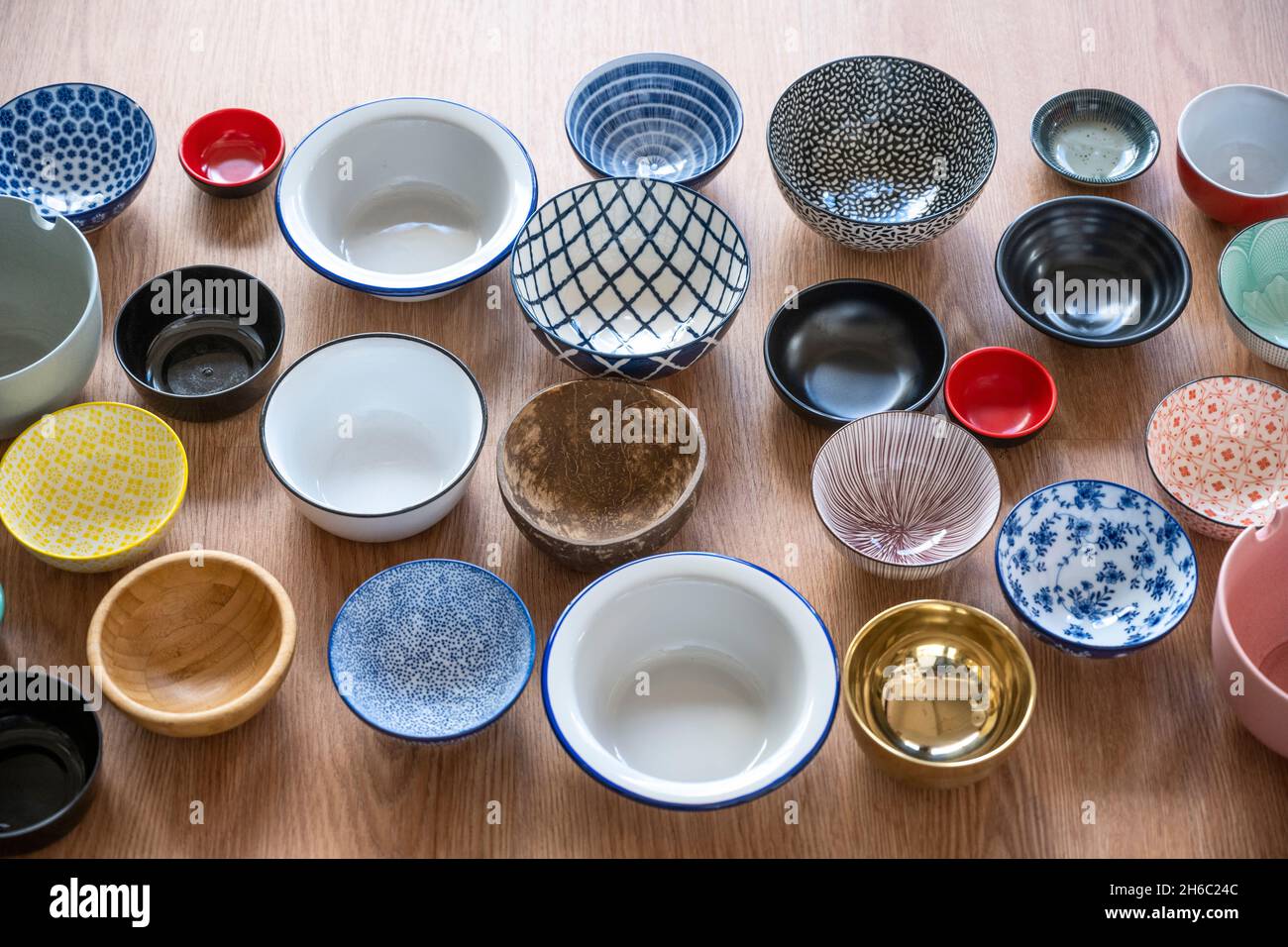Set of empty bowls of different textures and colors on oak background ...