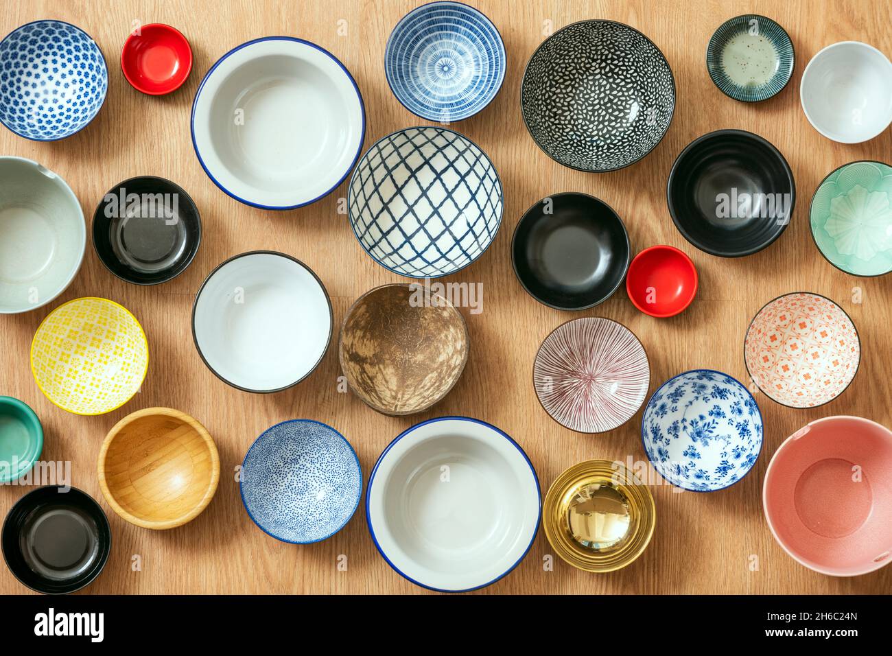 Set of empty bowls of different textures and colors on oak background ...