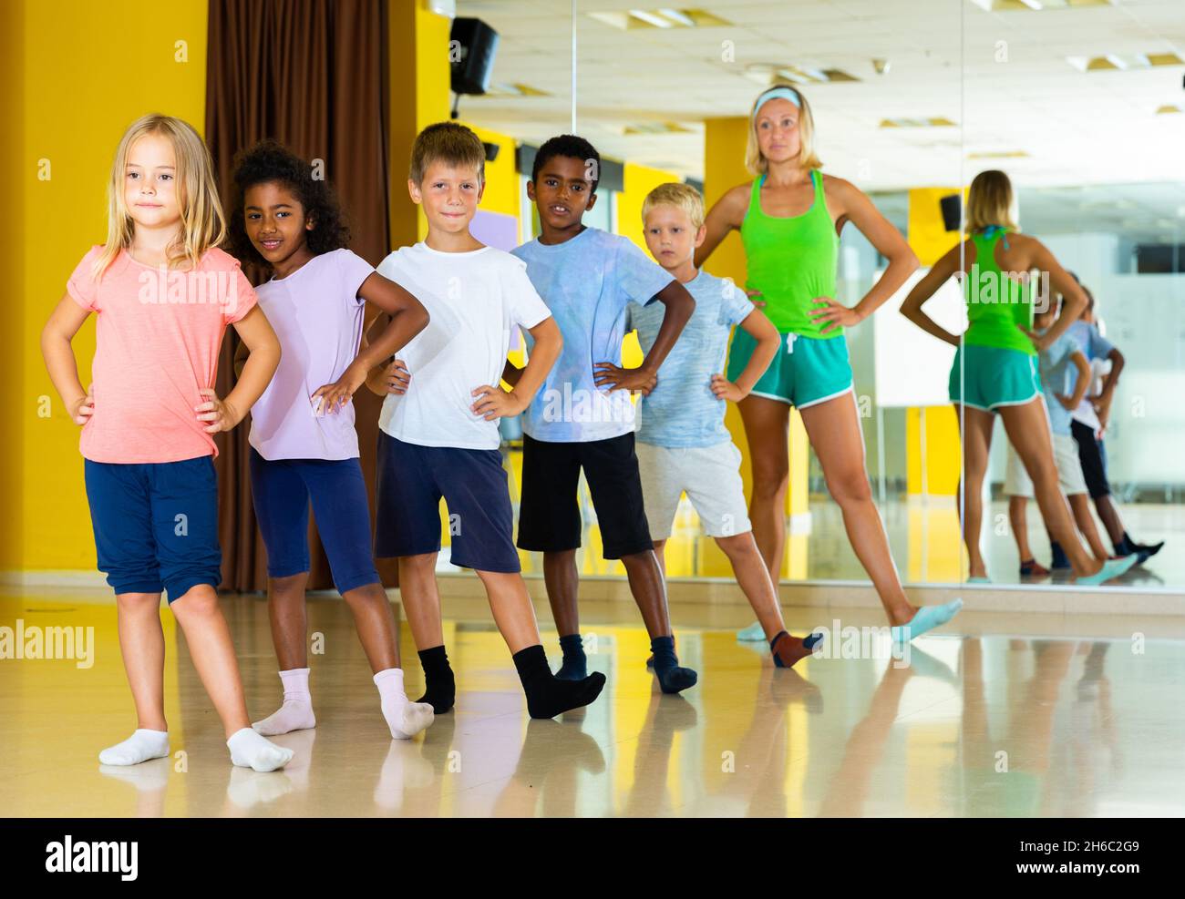 Positive little boys and beautiful girls having dancing class Stock ...