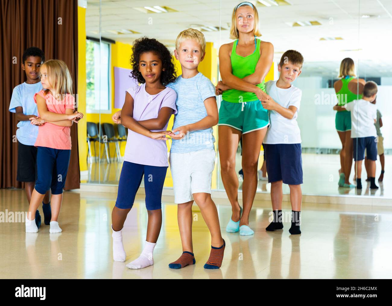 boys and girls dancing rock-and-roll in pairs with female trainer Stock ...