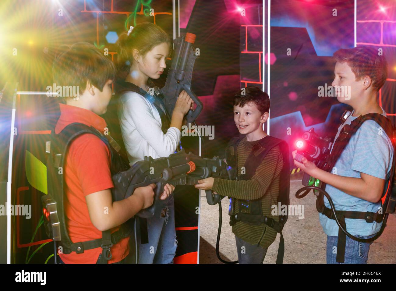 Jolly teens aiming laser guns at other players Stock Photo - Alamy