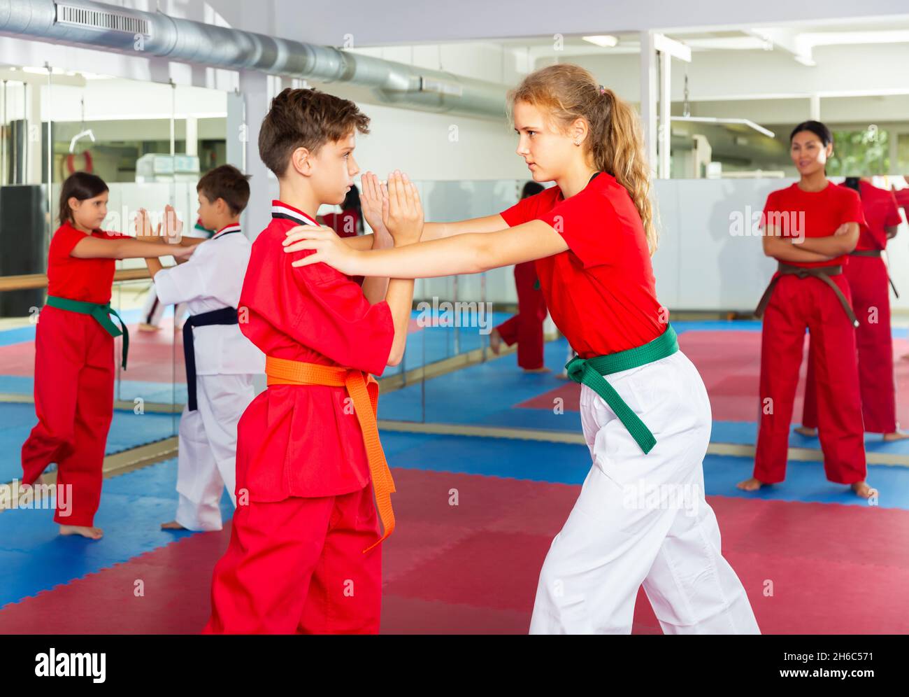 Children sparring in pairs to practice new moves in karate class Stock ...