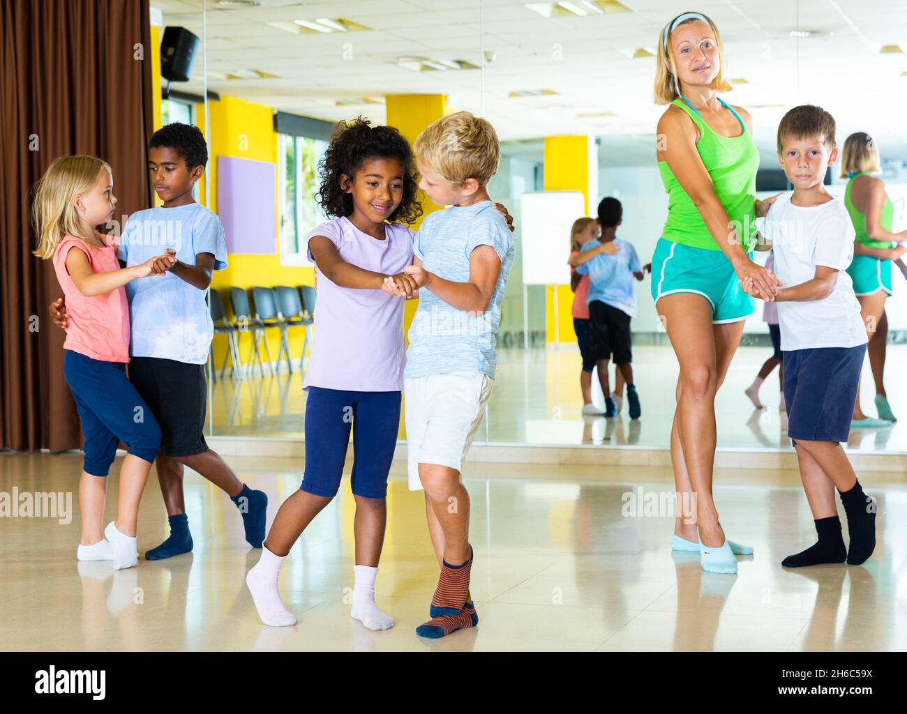Positive little boys and girls dancing pair dance in the ballet studio ...