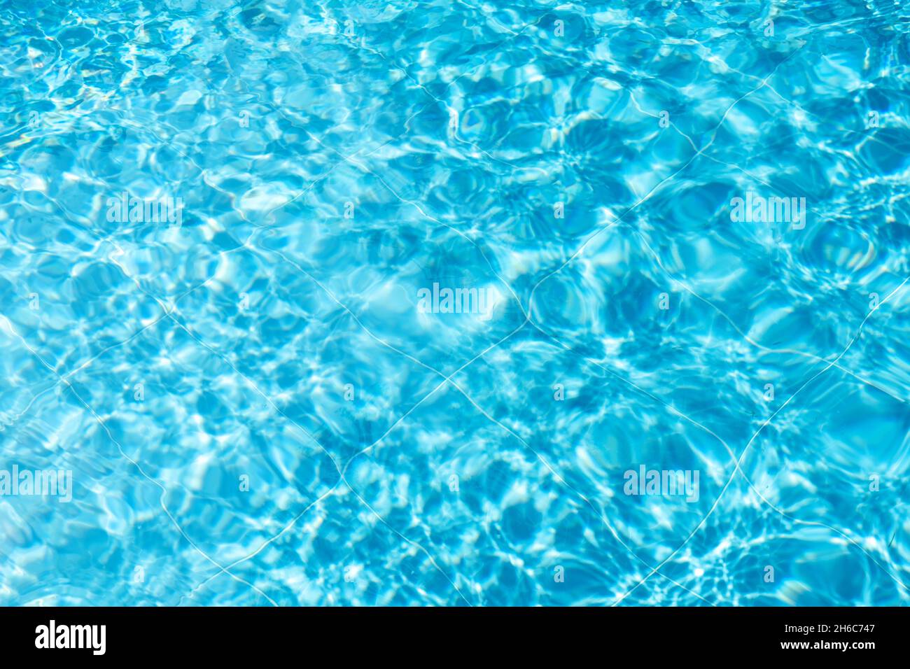 Summertime background with turquoise textured water in swimming pool ...