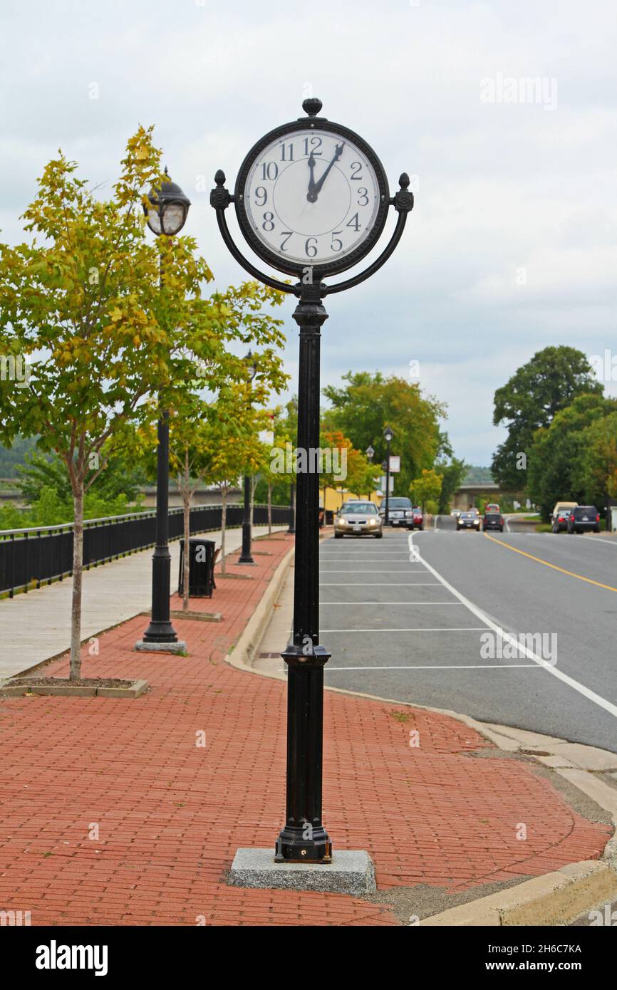 Vintage round street clock on a pole on paved bricks Stock Photo - Alamy