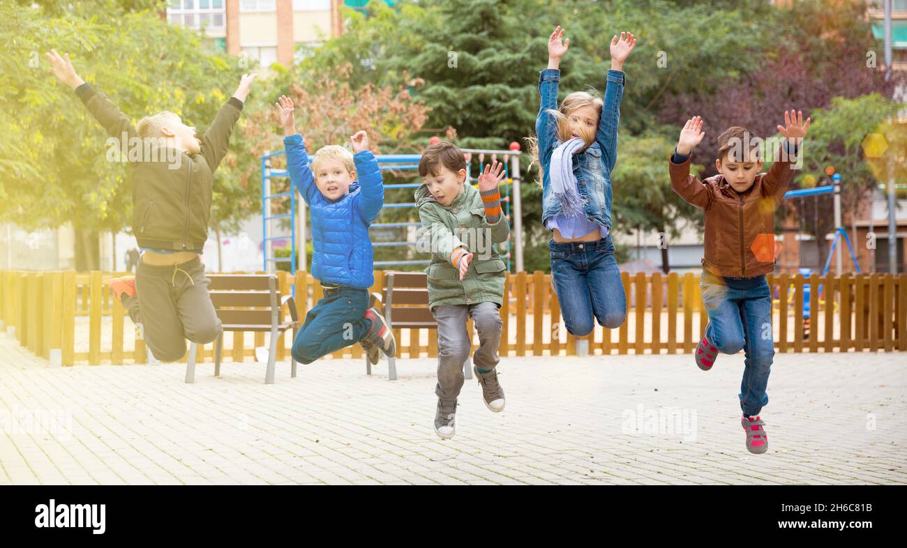 Happy children jumping together Stock Photo - Alamy