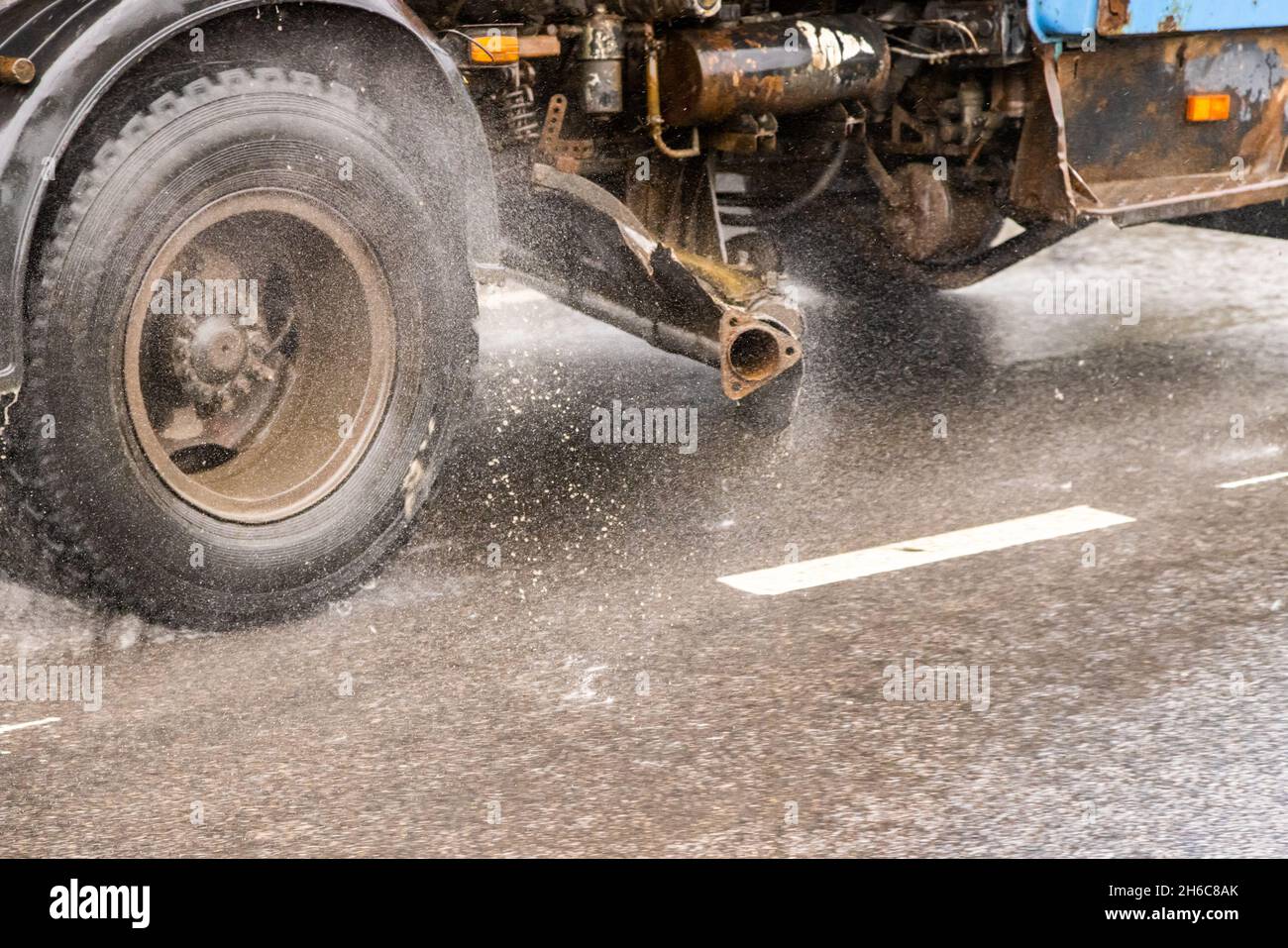 old utility truck moving on asphalt road under rainy day - close-up ...
