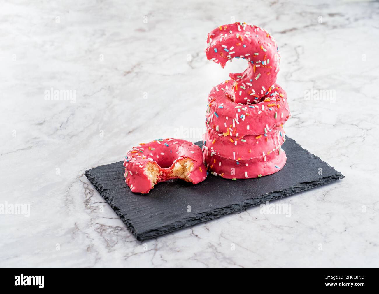 Closeup shot of delicious donuts with sprinkles on the table Stock Photo - Alamy