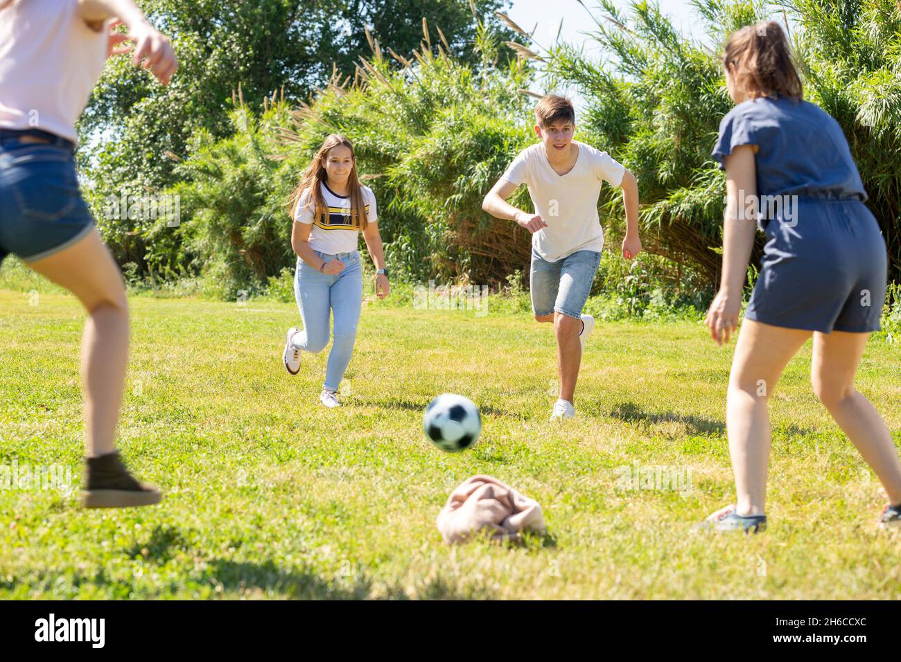 Cheerful teen friends playing with ball outdoors Stock Photo - Alamy