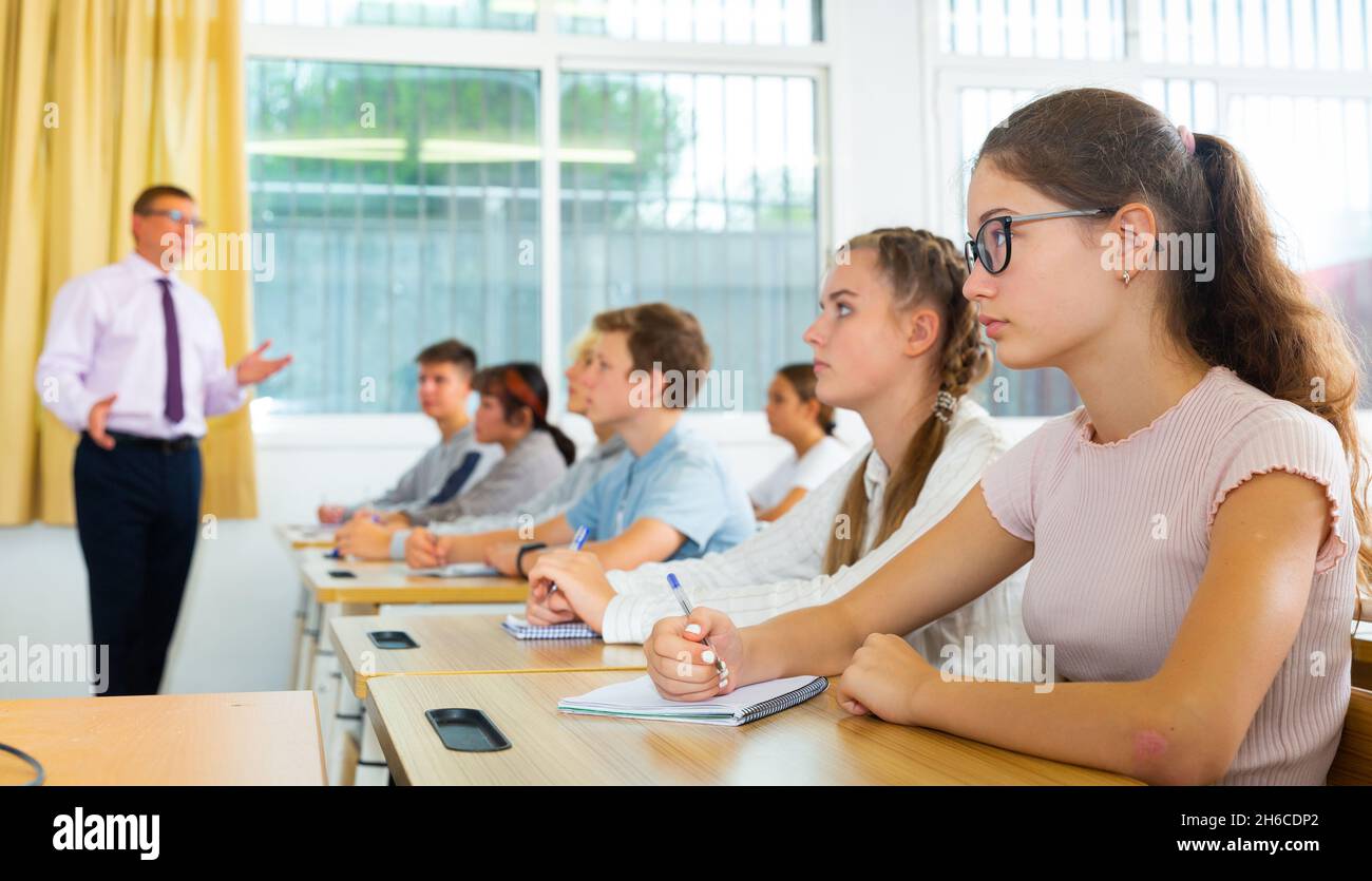 Teenage students working at class during lesson Stock Photo - Alamy