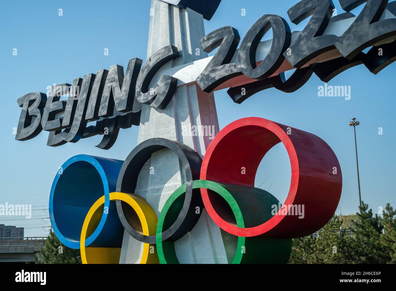 Urban ecological workers work in front of a huge emblem of Beijing 2022 ...