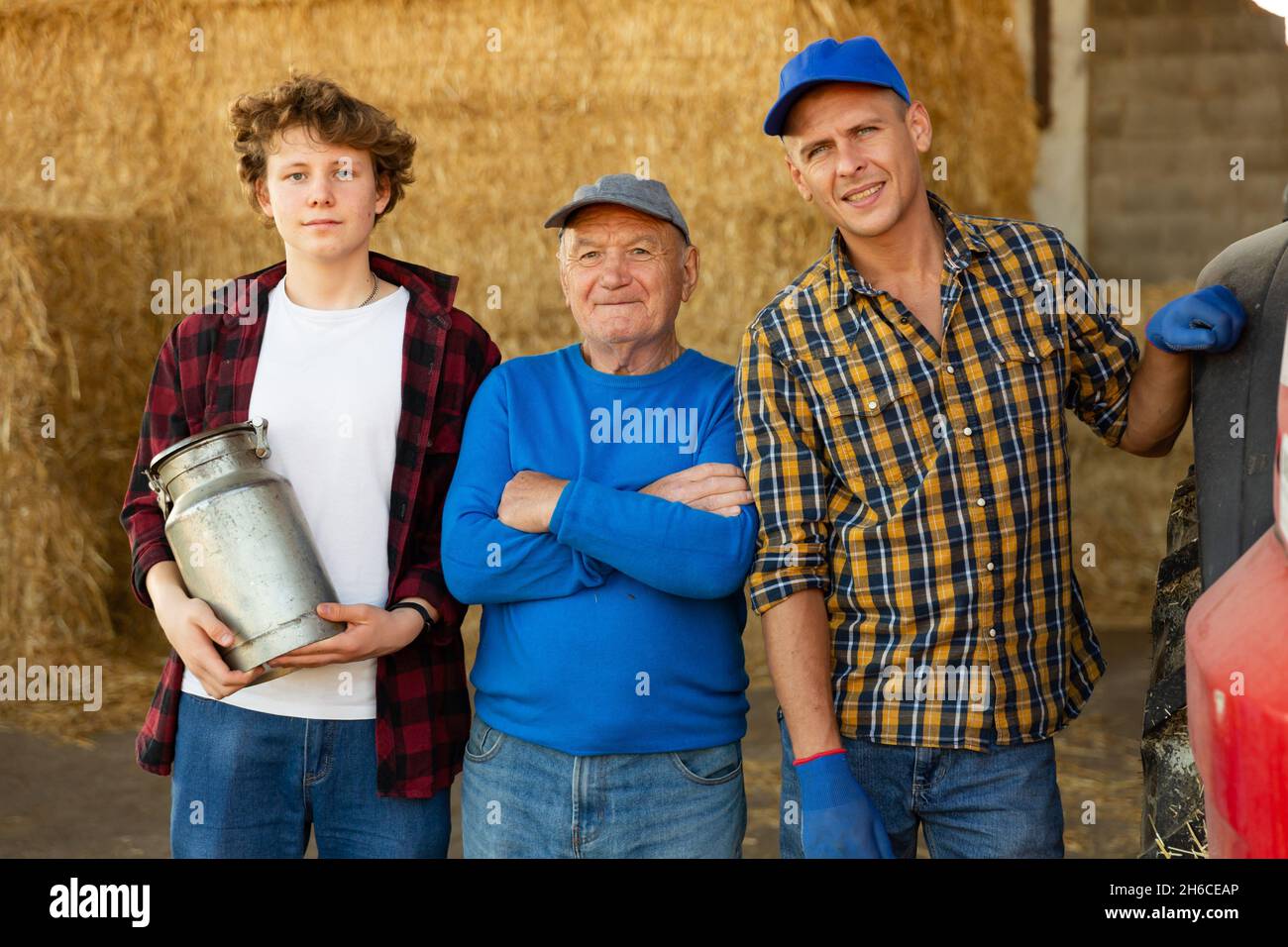 Three farm workers of different ages in barn Stock Photo - Alamy