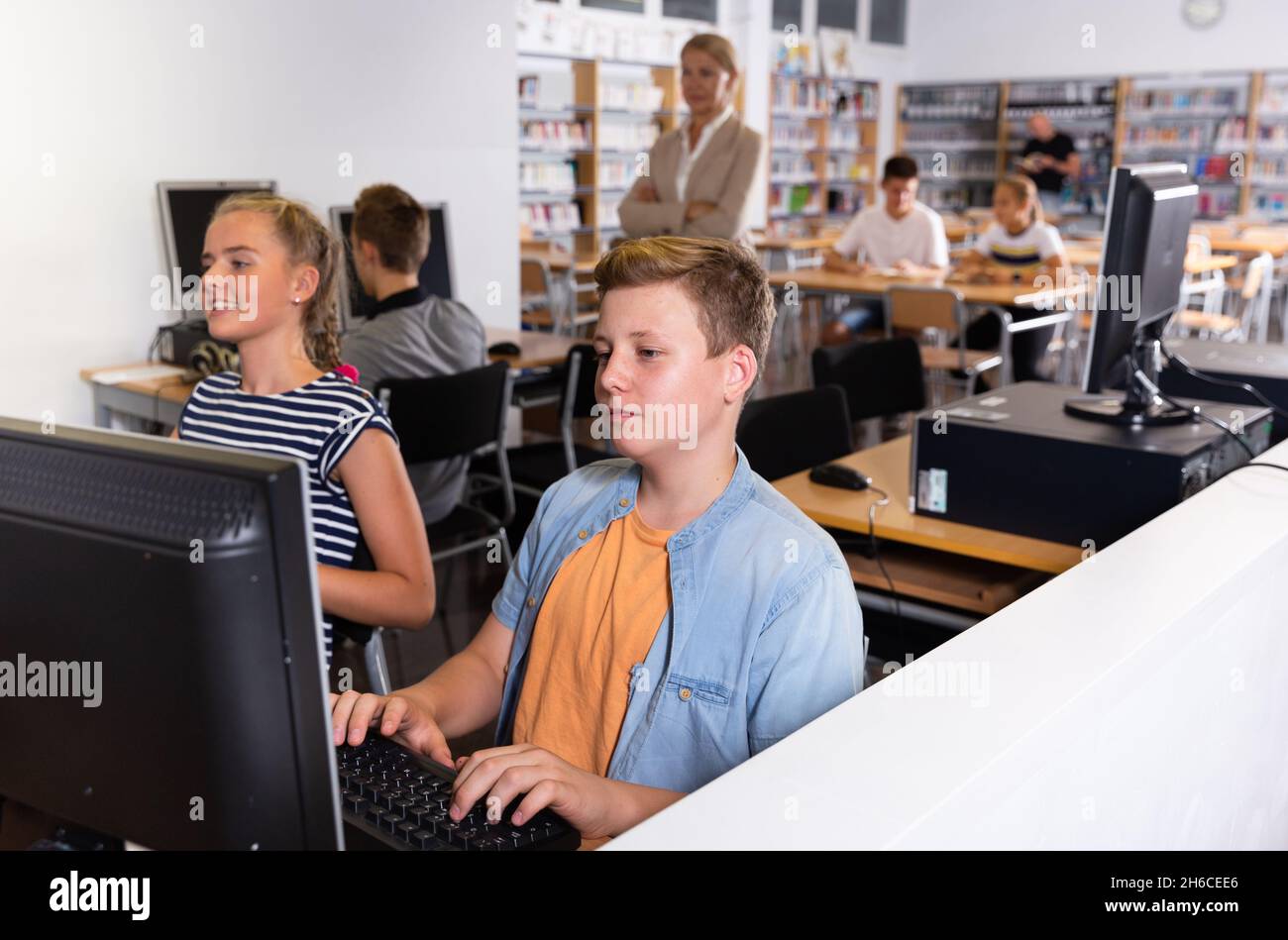 Boys and girls using computers in IT room Stock Photo - Alamy