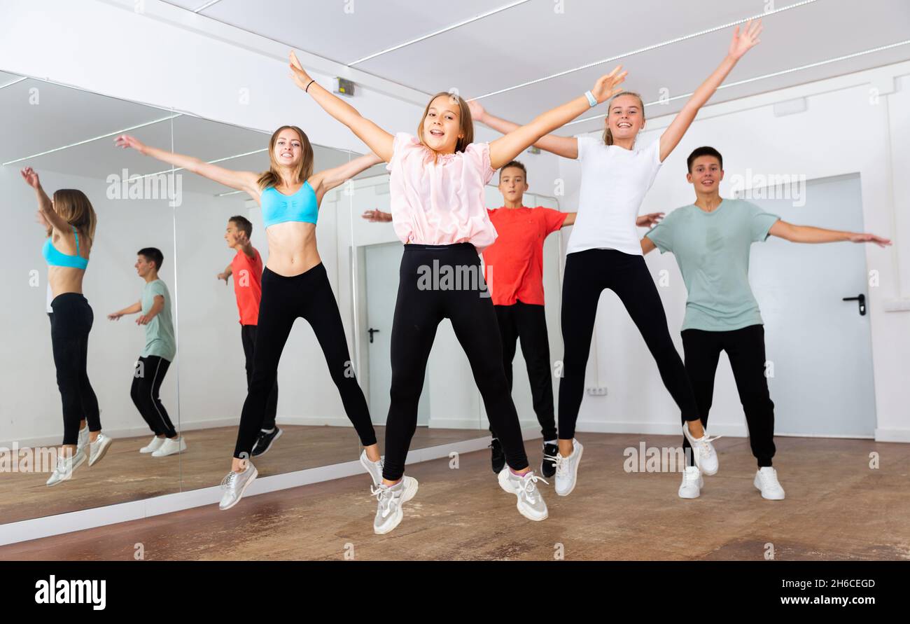 Happy teens jumping in choreography class Stock Photo - Alamy