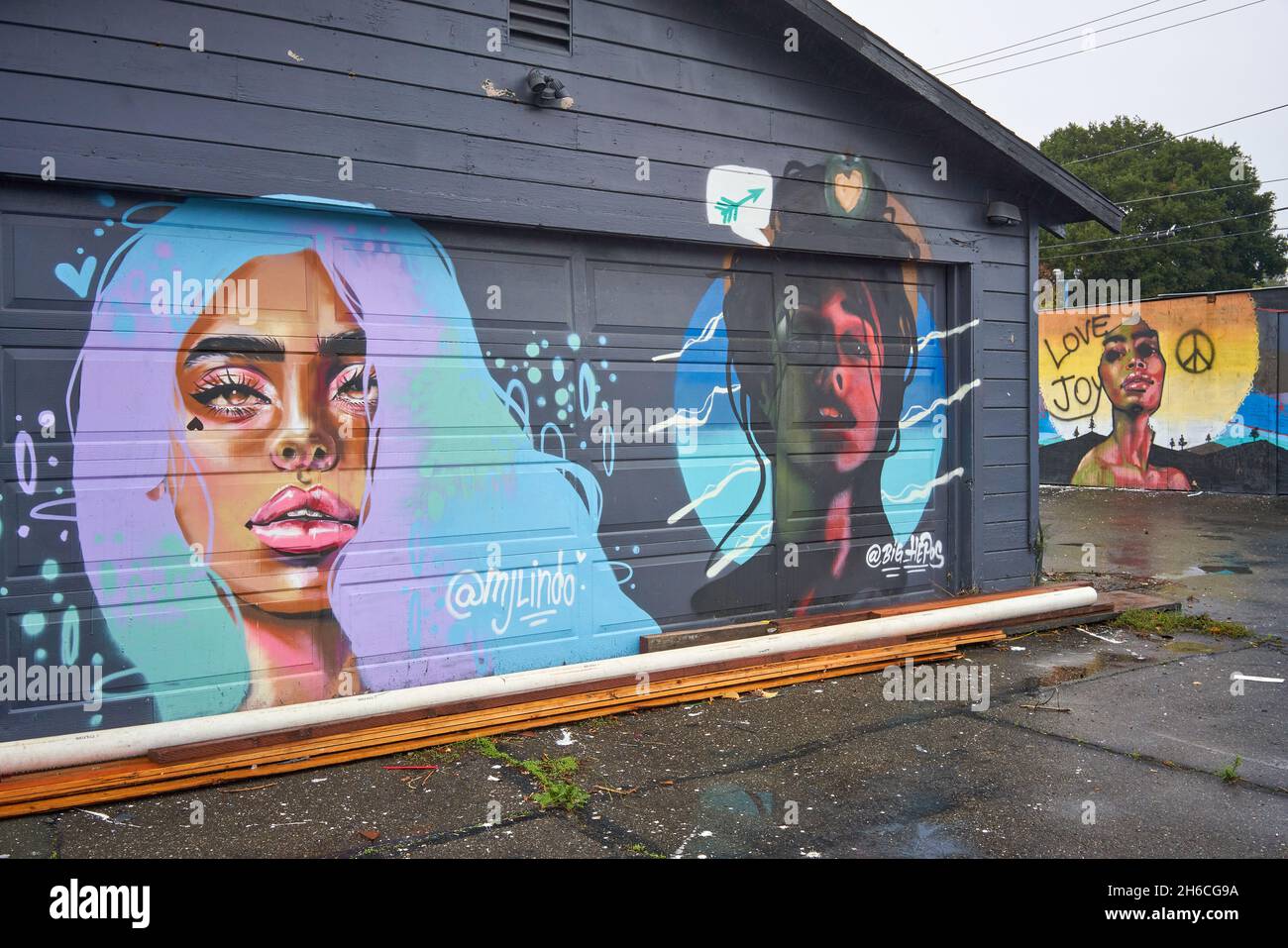 Street graffiti artwork of female faces, colorful, with words Love and ...