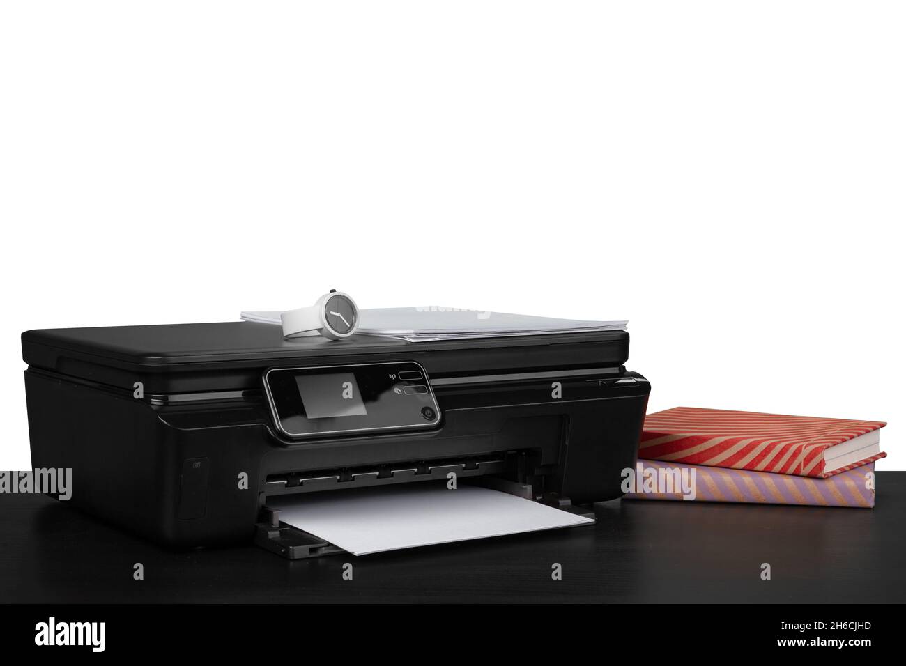 Printer and stack of books on black table against white background ...