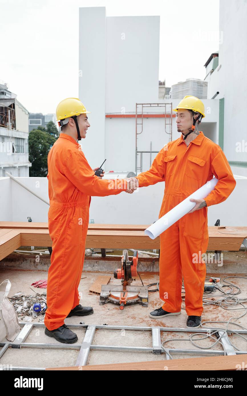 Contractor and foreman shaking hands after finishing productive day of ...