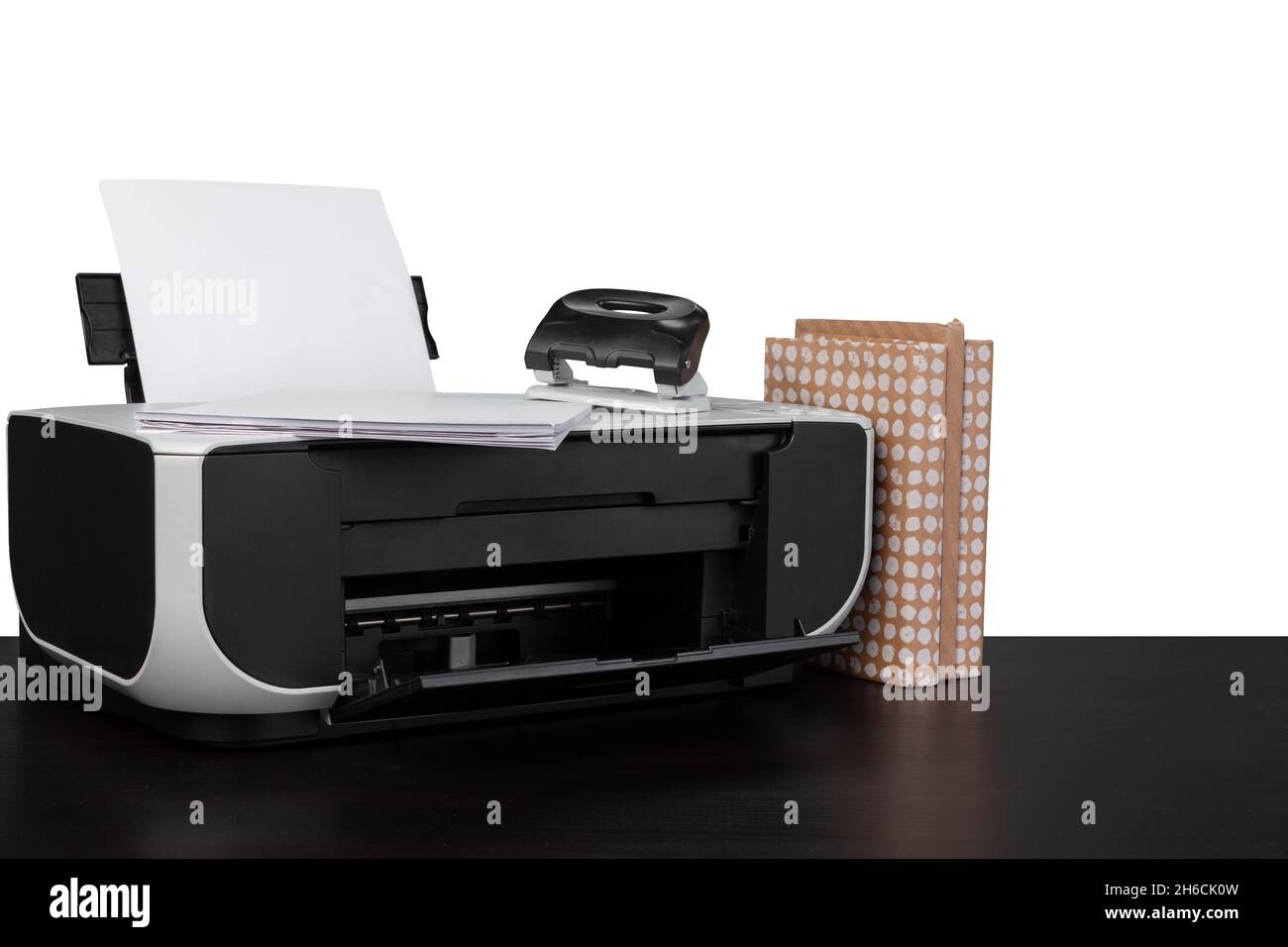 Printer and stack of books on black table against white background ...