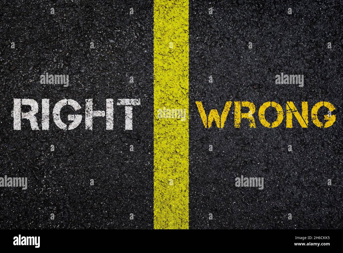 Antonym concept of RIGHT versus WRONG, written on dark wet asphalt. Top ...