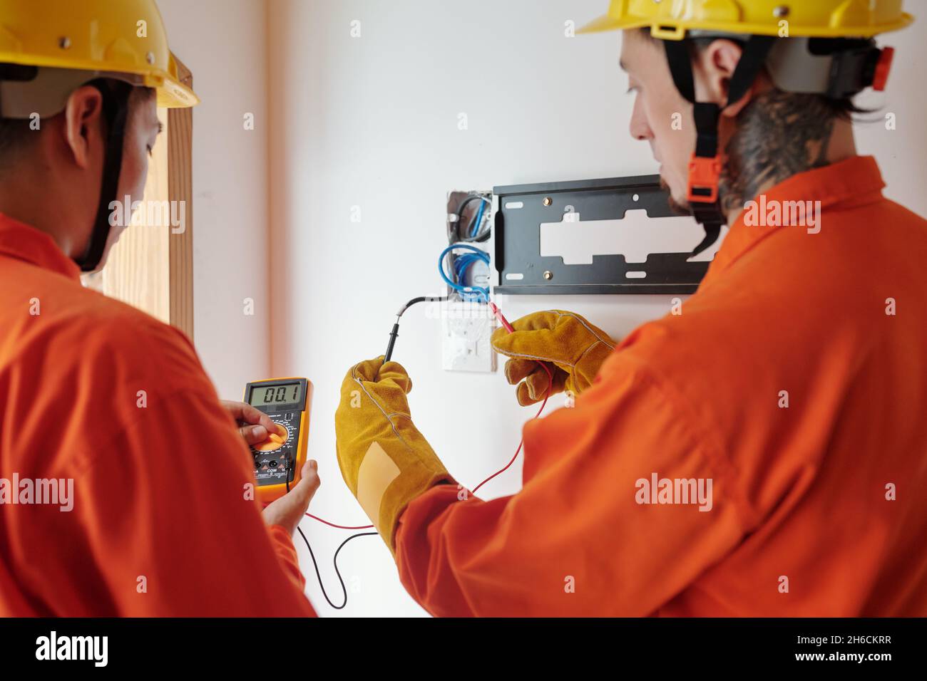 Electricians wearing protective gloves when testing electrical wires ...