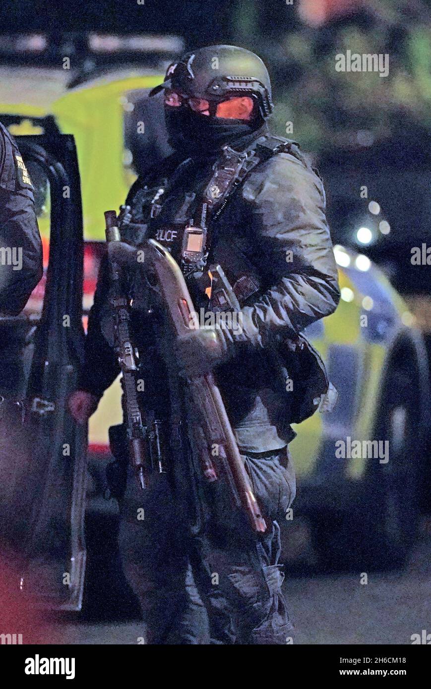 An armed police officer holds a breaching shotgun, used to blast the ...