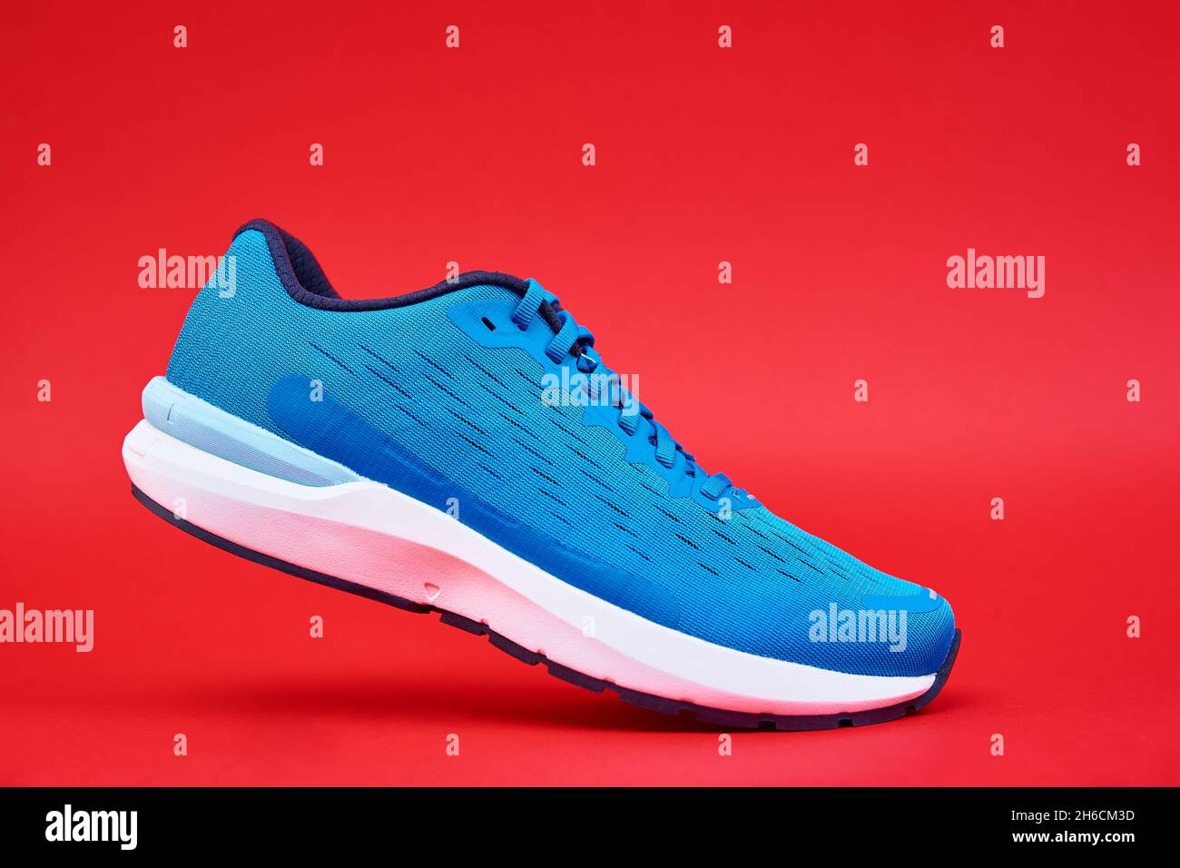 Blue running sneaker on red background. Sport male shoe steps on red ...