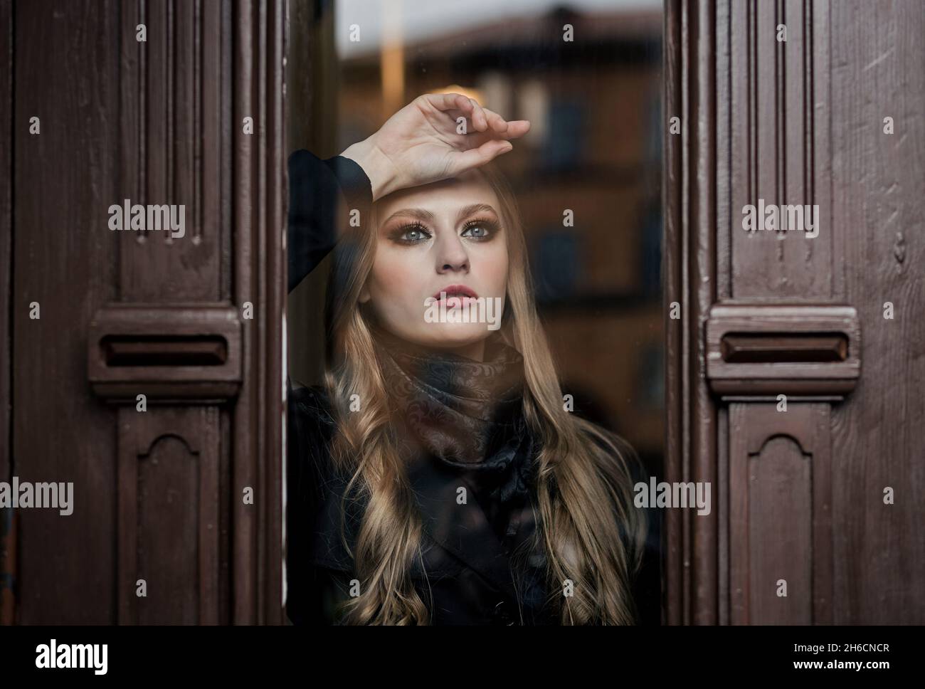 portrait woman behind the glass. Sensual female model looking through ...