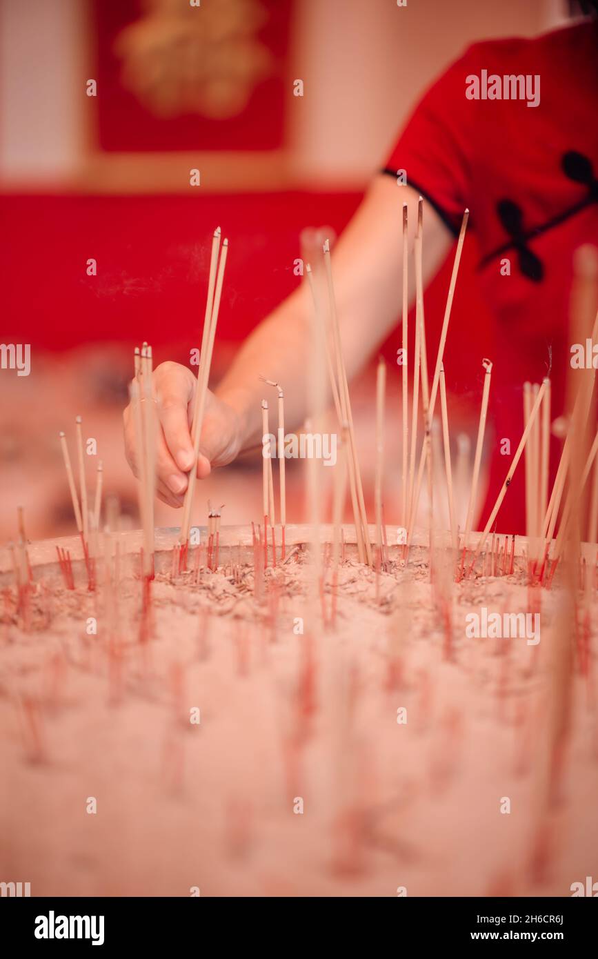 Hands stab Incense sticks on joss stick pot burning and smoke used to ...