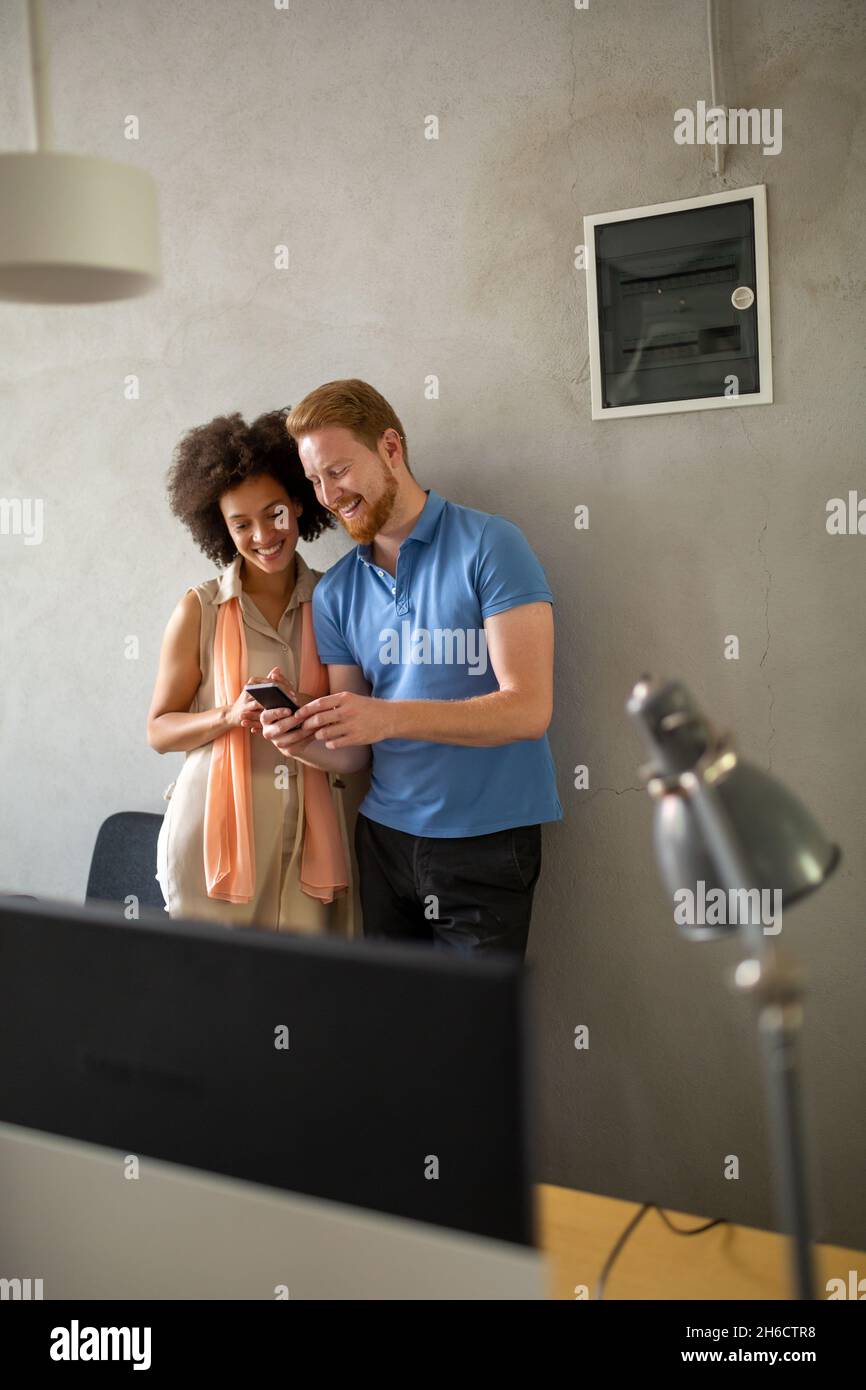 Happy business people having fun and chatting at workplace office ...