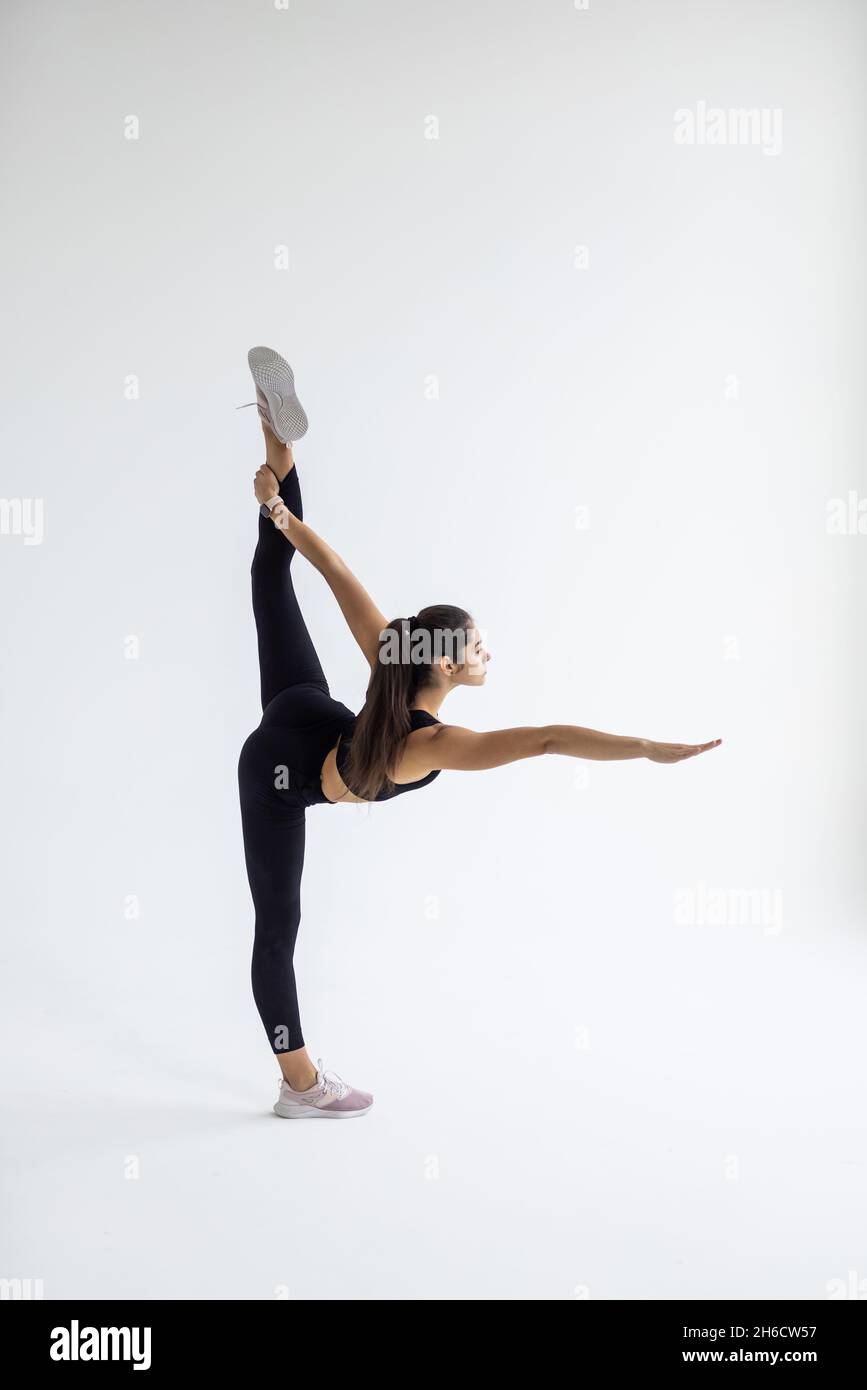 Young modern flexible woman standing on one leg splits standing on ...