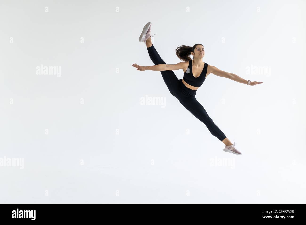 Portrait of beautiful young brunette woman gymnast training ...