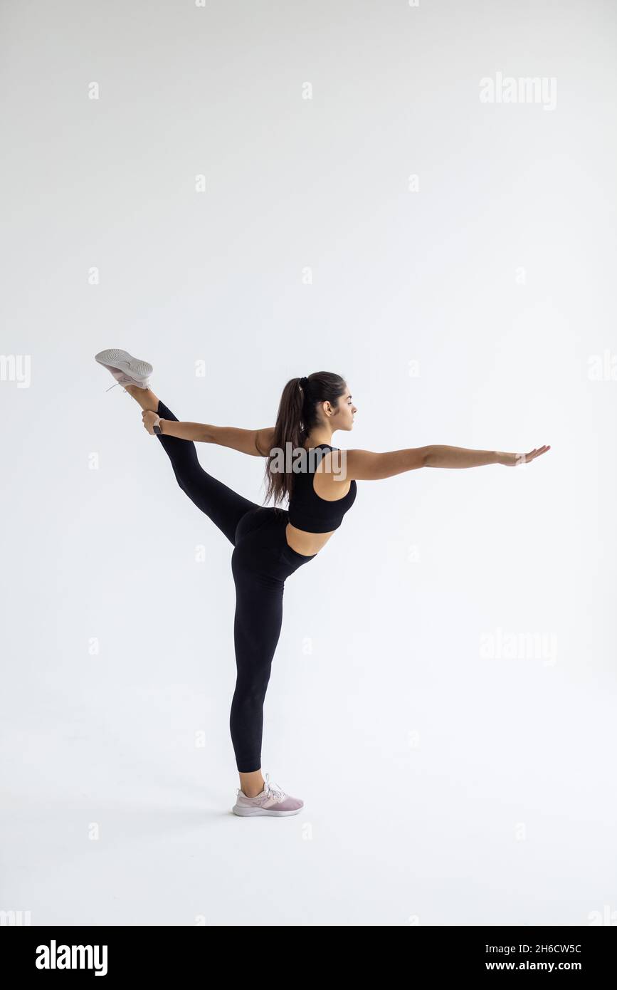 Young modern flexible woman standing on one leg splits standing on ...
