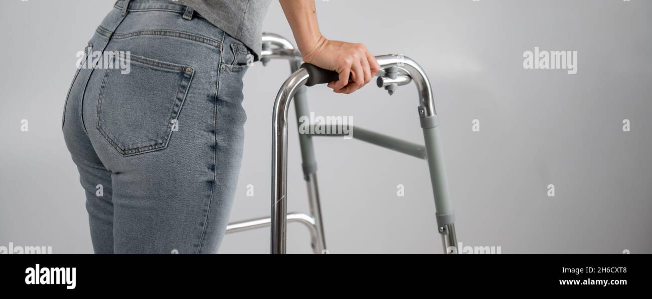 A woman is walking with a walker on a white background Stock Photo - Alamy