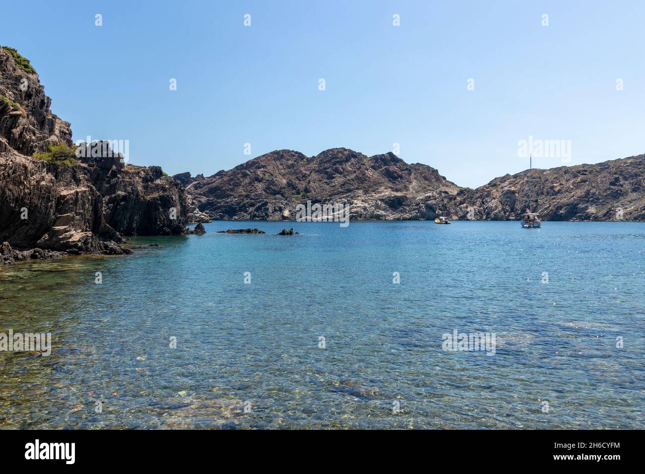 boats sailing in a small bay of cap de creus on a sunny summer day ...
