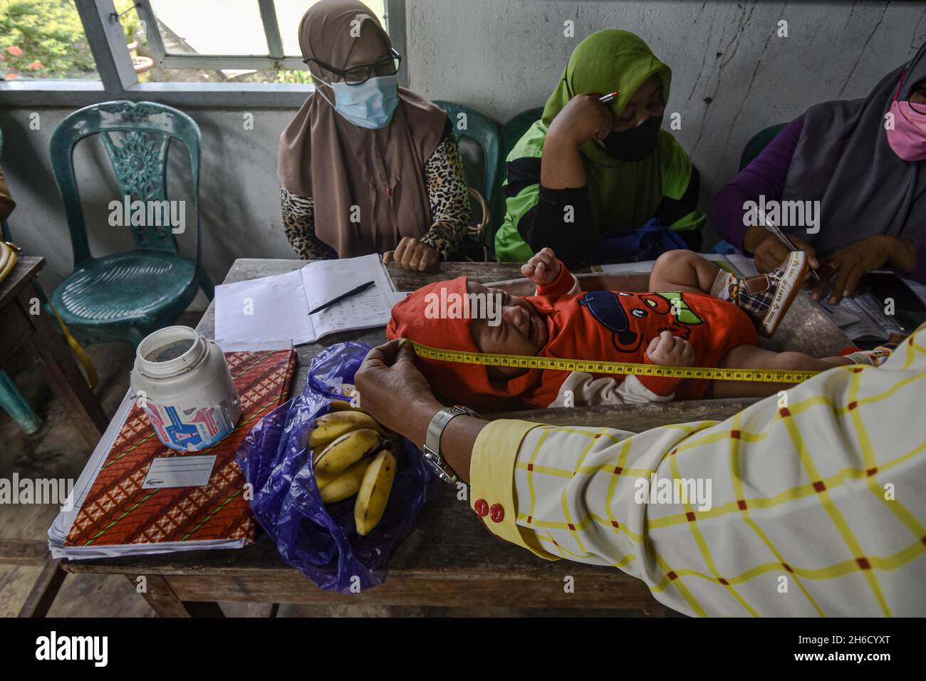 Soppeng, Indonesia. 15th Nov, 2021. Health workers measure the baby's ...